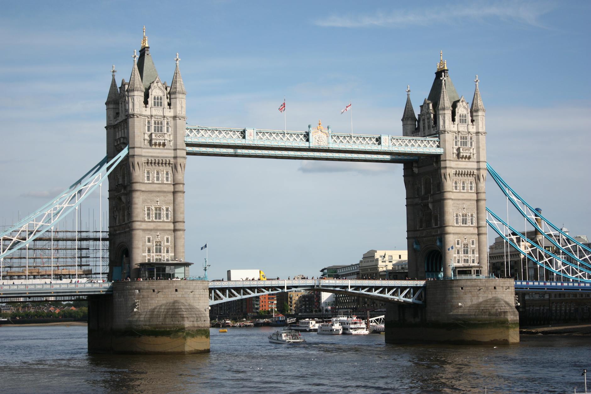 Tower Bridge from river level with small boats and clear blue sky