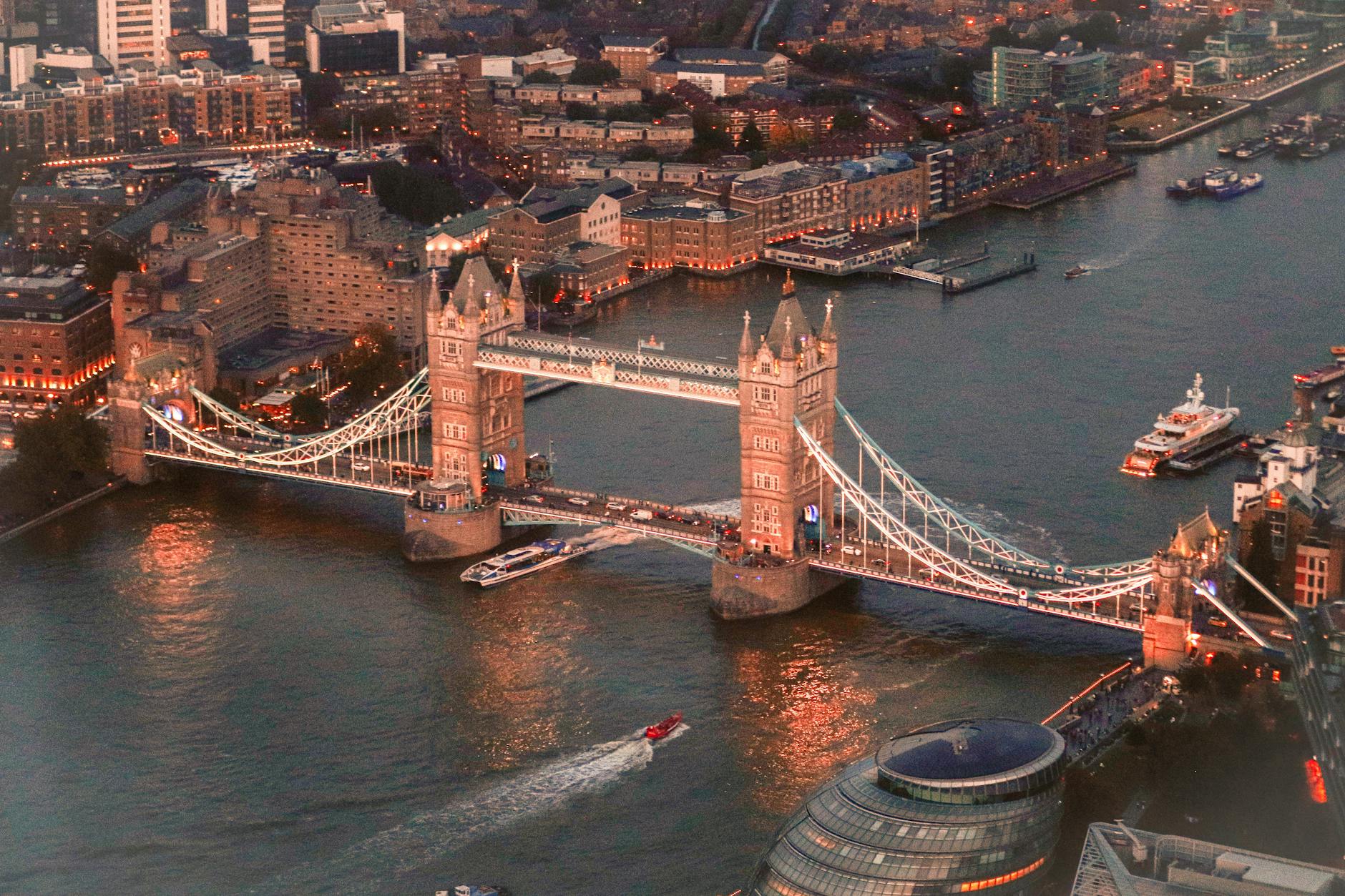 Aerial view of Tower Bridge at sunset with warm golden light on the river