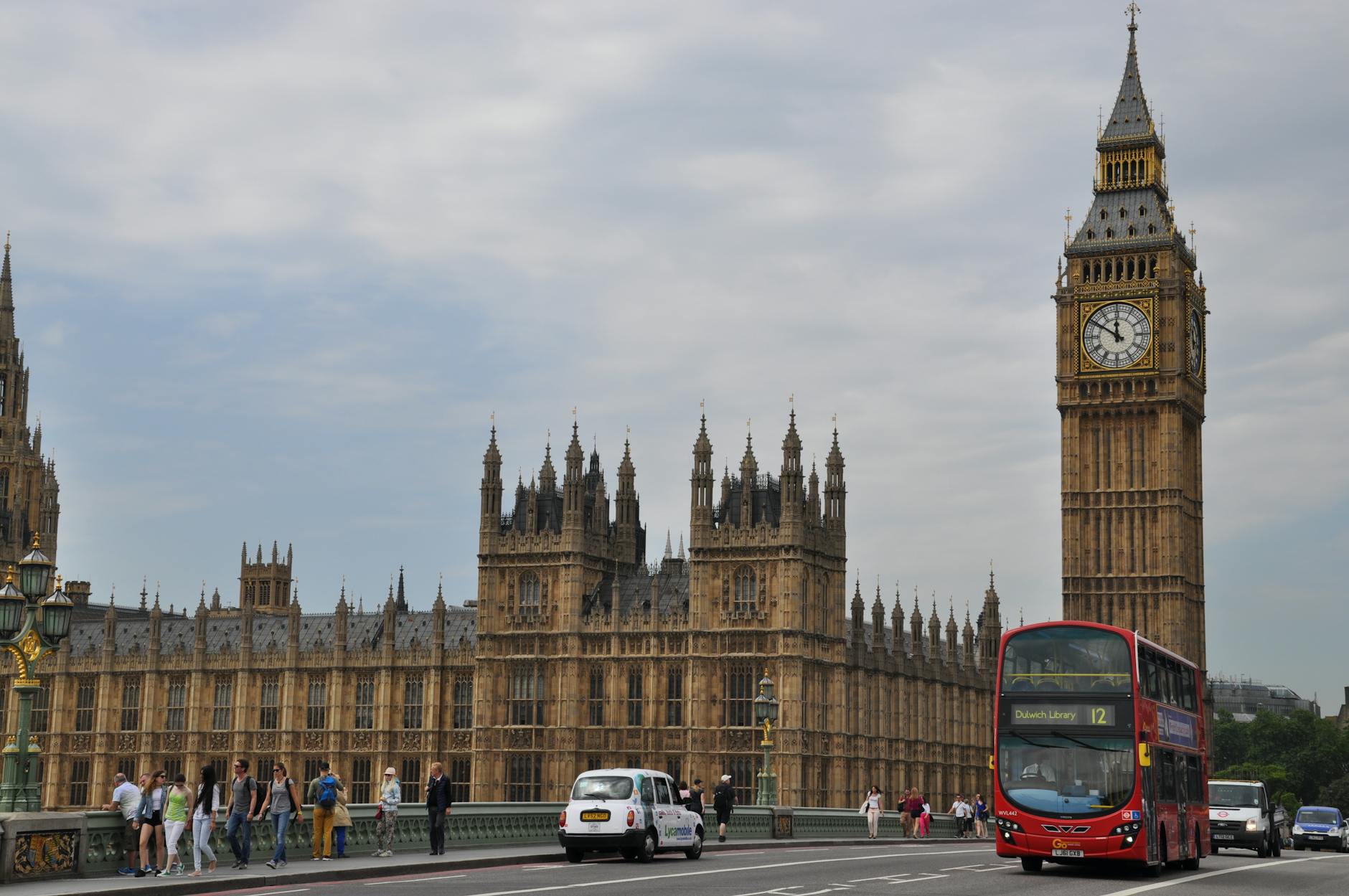 Big Ben and red London bus crossing Westminster Bridge