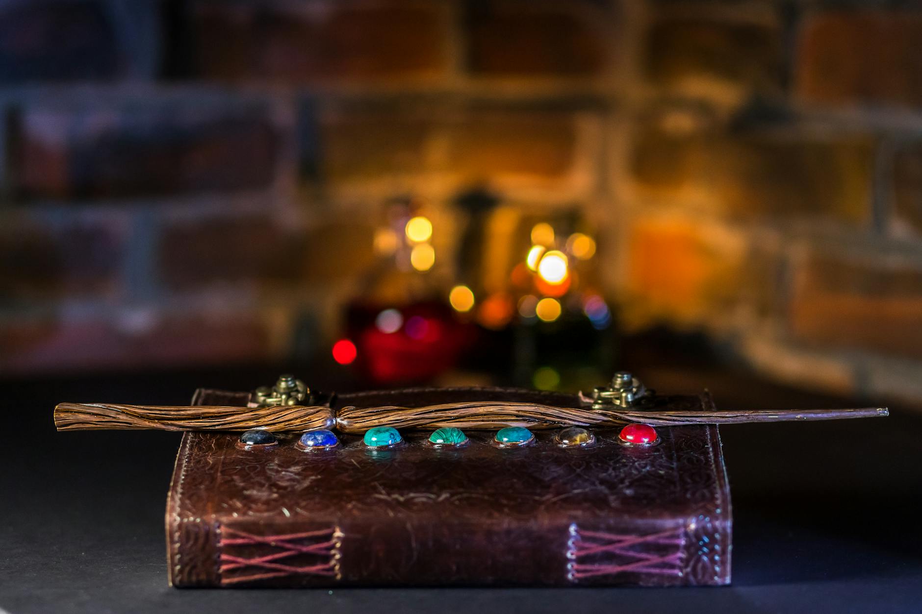 Close-up of a magical wand resting on a spell book with colorful potions
