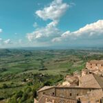 Aerial view of Montepulciano perched on a hilltop surrounded by Tuscan vineyards and rolling green hills