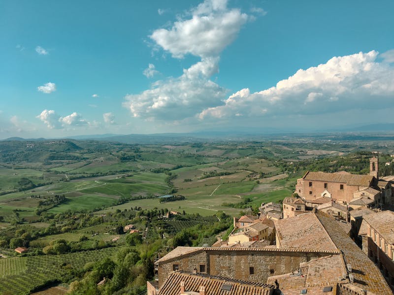 Aerial view of Montepulciano perched on a hilltop surrounded by Tuscan vineyards and rolling green hills