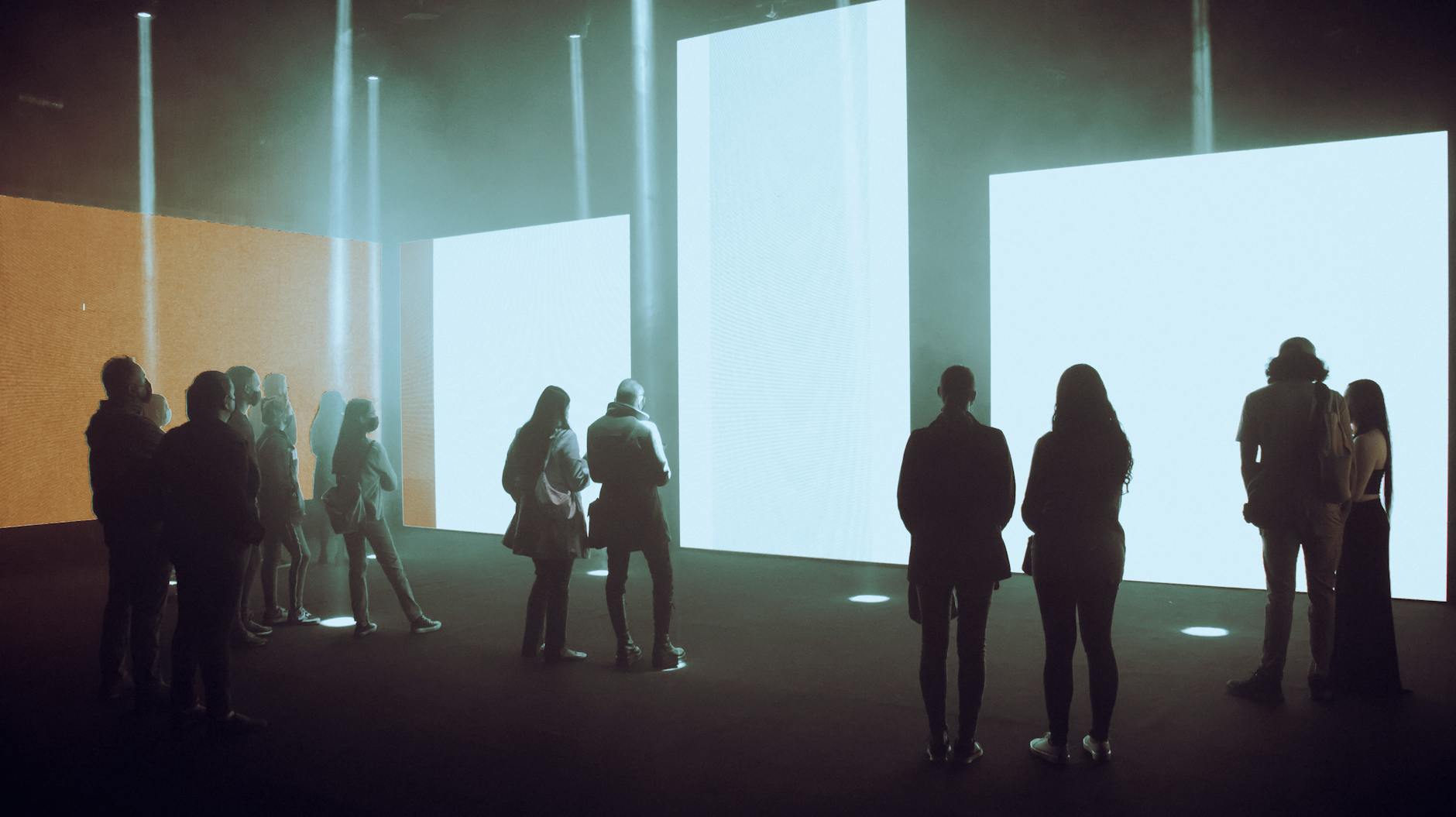 Visitors exploring an immersive digital art exhibition with large illuminated screens
