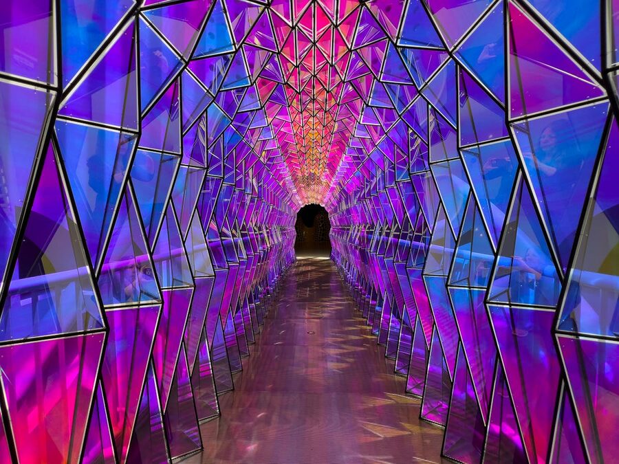 Geometric tunnel illuminated with deep purple and blue neon lights