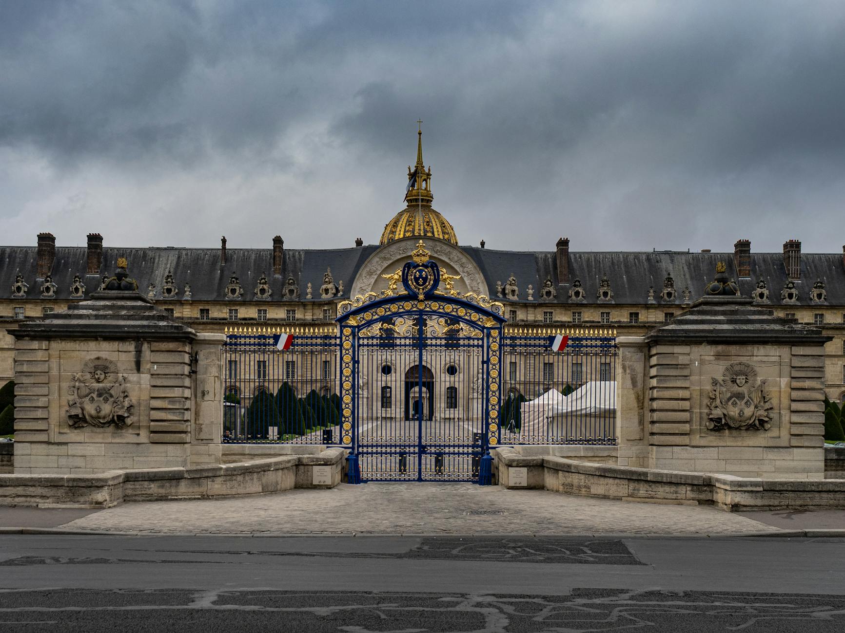 The ornate iron gates and facade of Les Invalides with its golden dome visible behind