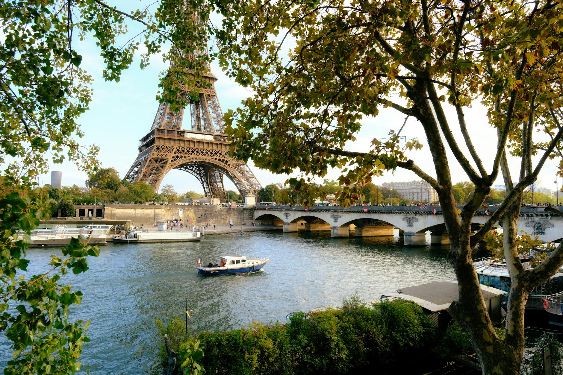 View of the Eiffel Tower from across the Seine River in Paris with trees in the foreground