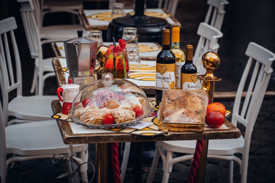 Outdoor dining table with Italian food wine and rustic setting in warm evening light