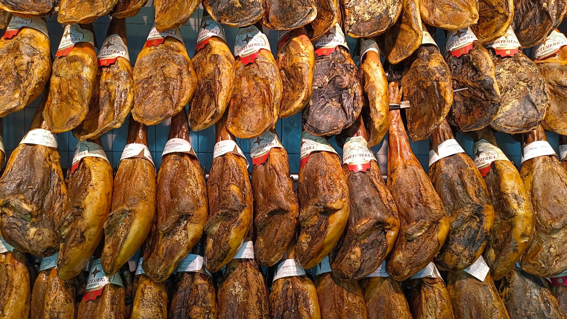 Traditional jamon iberico hanging in a Spanish market