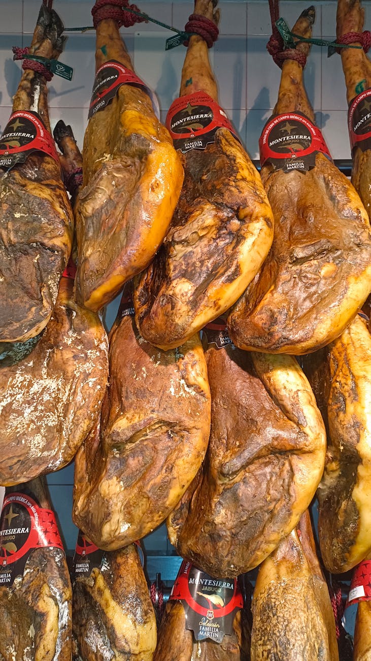 Jamon iberico hams hanging on display in a Spanish market