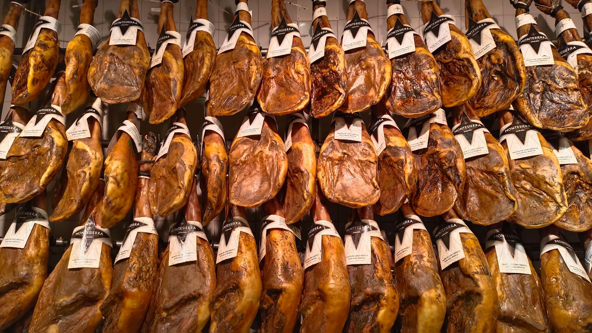 Display of jamon iberico hams hanging in a Spanish market stall