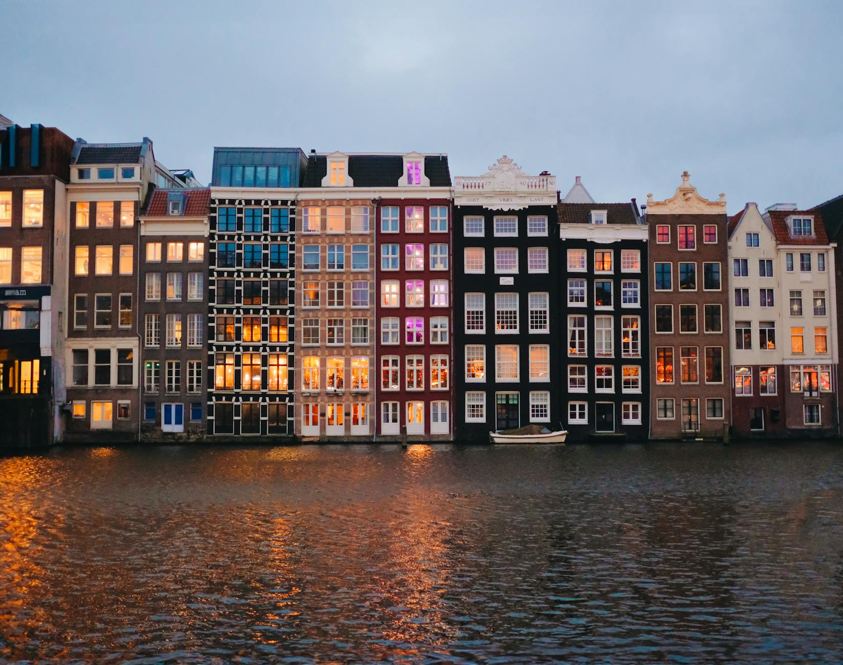 Iconic Amsterdam canal houses reflecting on the water at dusk
