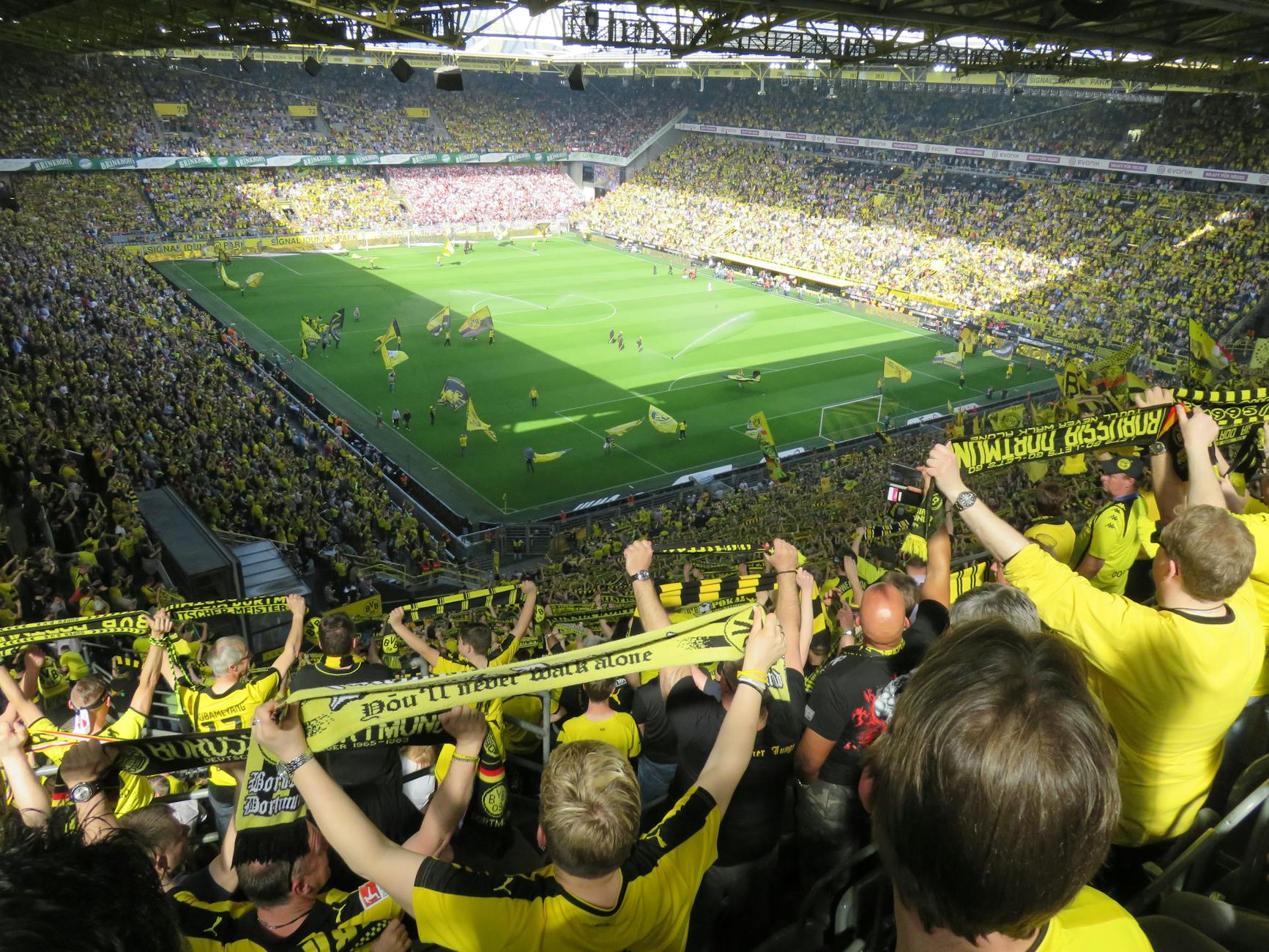 Excited fans cheering during a football match in a European stadium