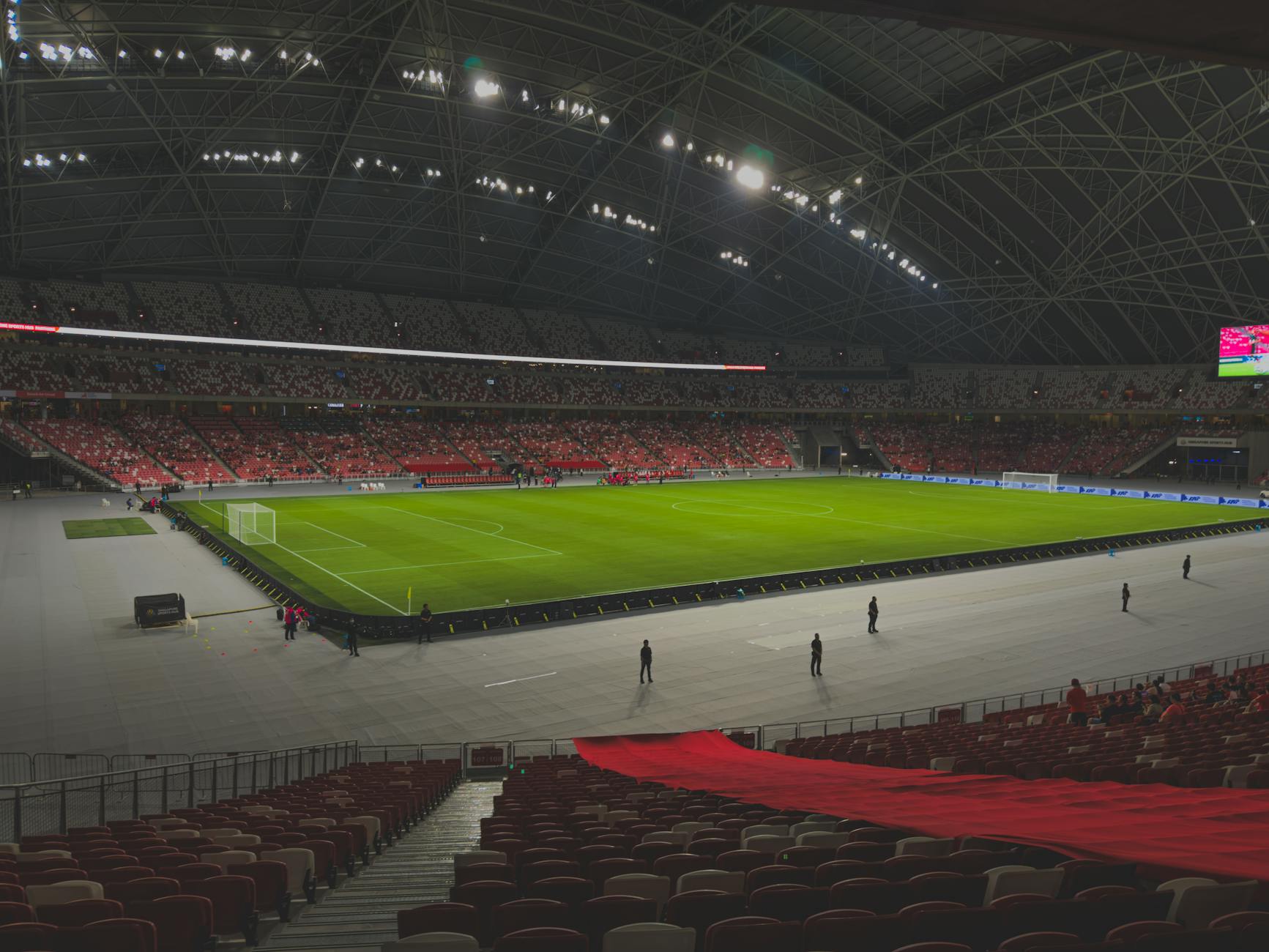 Spacious indoor stadium filled with spectators under bright lights