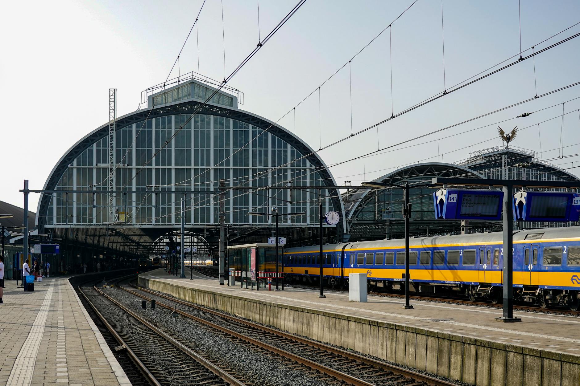 Exterior view of Amsterdam Central Station with a passenger train on the platform