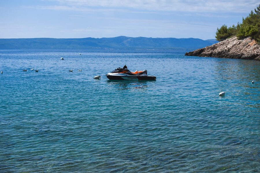 Jet ski moored near a rocky shoreline with calm sea
