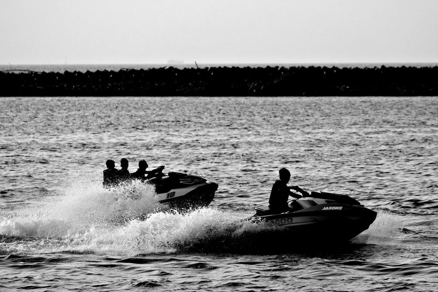 Silhouettes of jet skis racing across open water