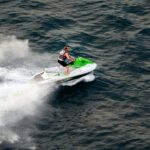 Person riding a jet ski at speed on open ocean waters