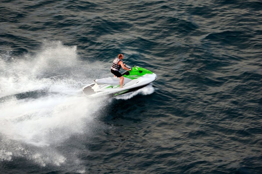 Person riding a jet ski at speed on open ocean waters