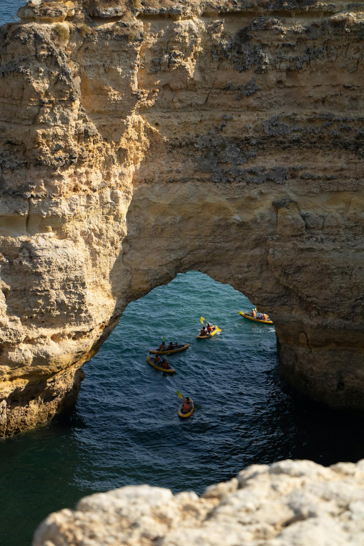Group of kayakers navigating through a natural sea cave