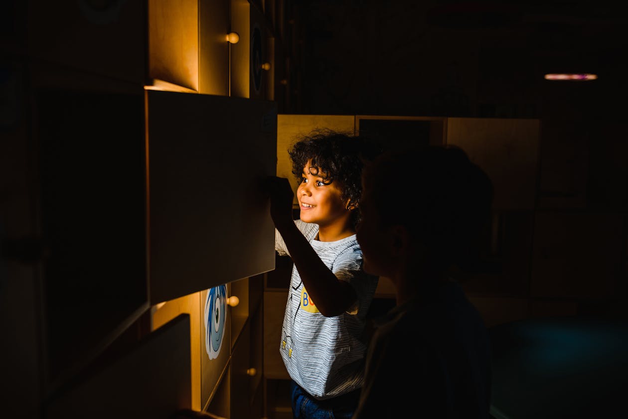 Two boys looking at a glowing educational display in a museum