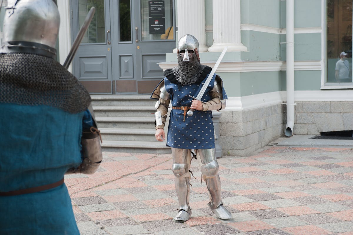 Two knights in full armor performing sword combat on a city street