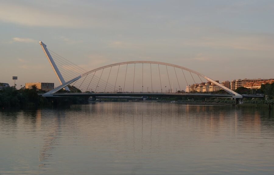 La Barqueta Bridge illuminated at evening over the Guadalquivir River in Seville