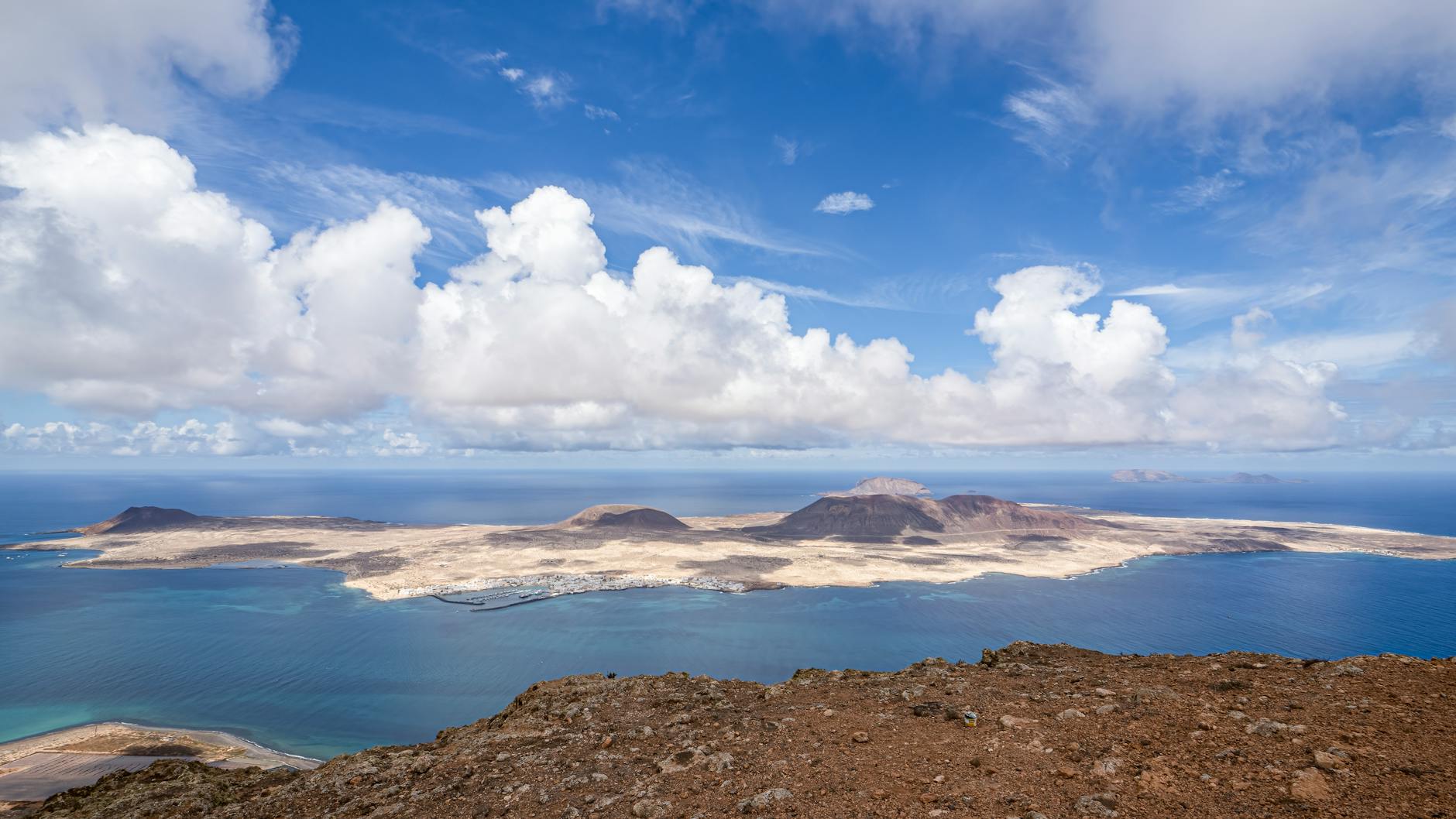 Aerial view of La Graciosa Island coastline with volcanic landscape and turquoise waters