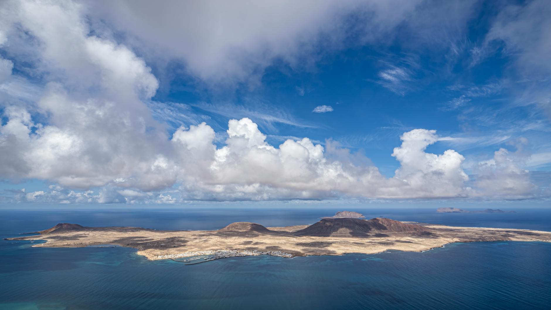 Aerial view of La Graciosa Island under blue skies with white clouds