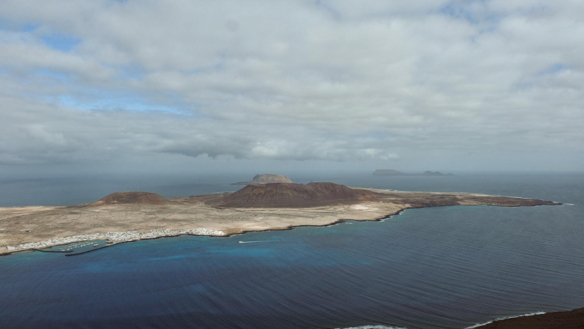 Aerial view of La Graciosa Island with ocean and dramatic clouds overhead