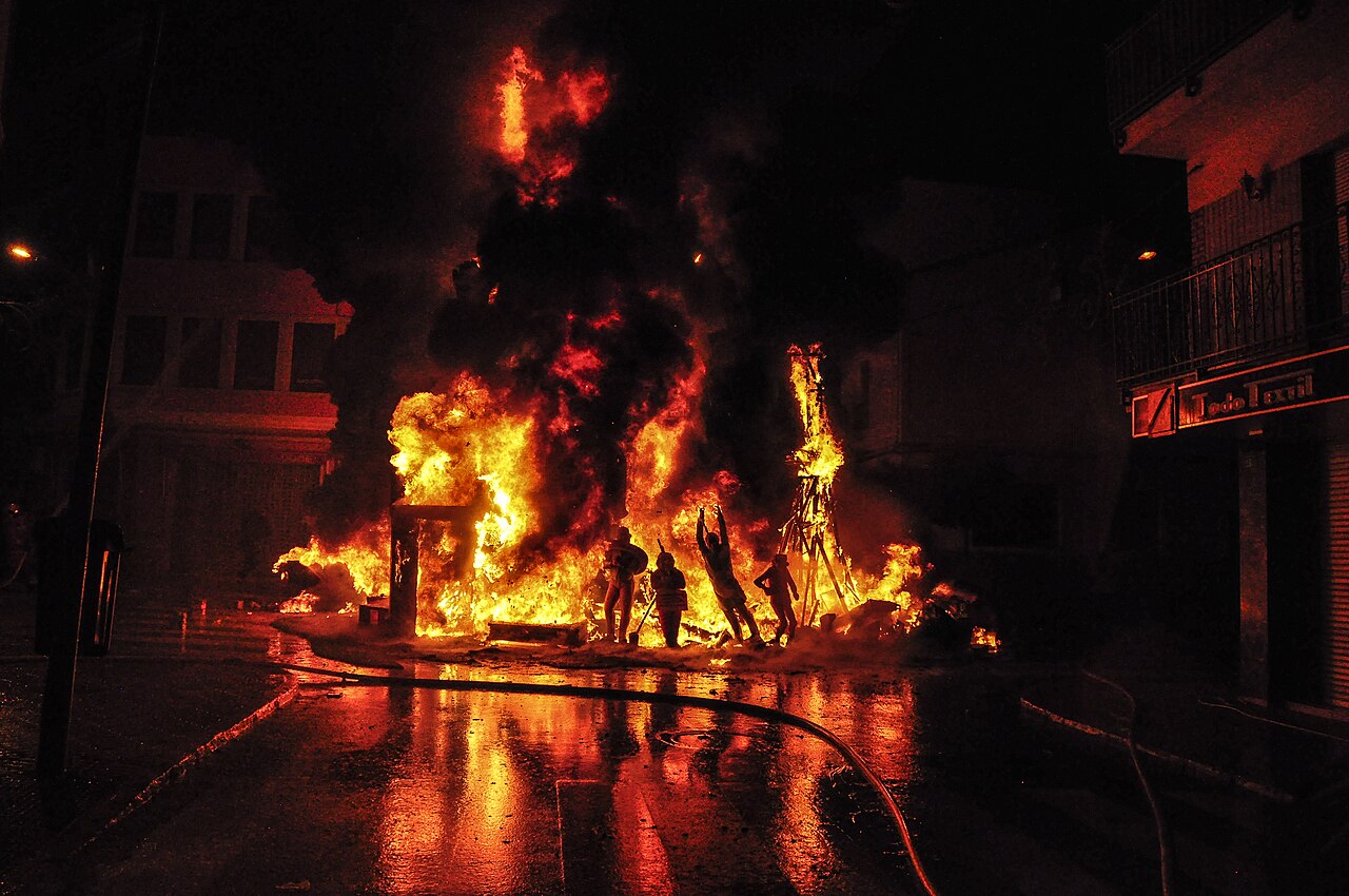 La Crema burning ceremony with firefighters spraying water hoses on the blazing falla monument