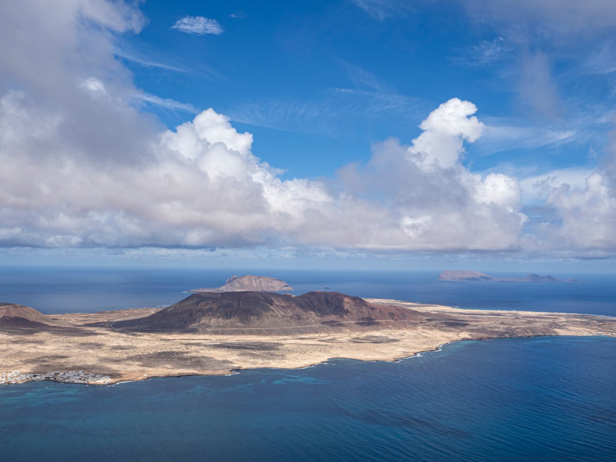 Aerial view of Lanzarote volcanic landscape and ocean under a cloudy sky