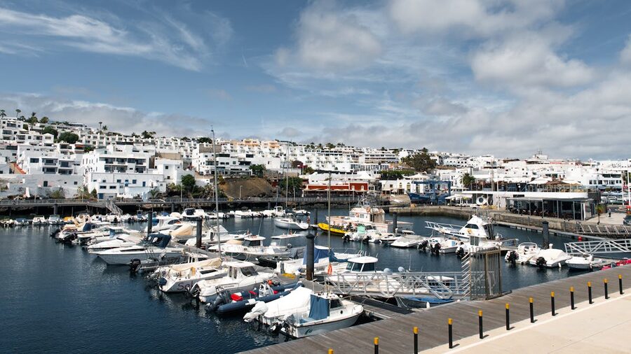 Scenic view of a marina with boats and white buildings in Lanzarote Canary Islands