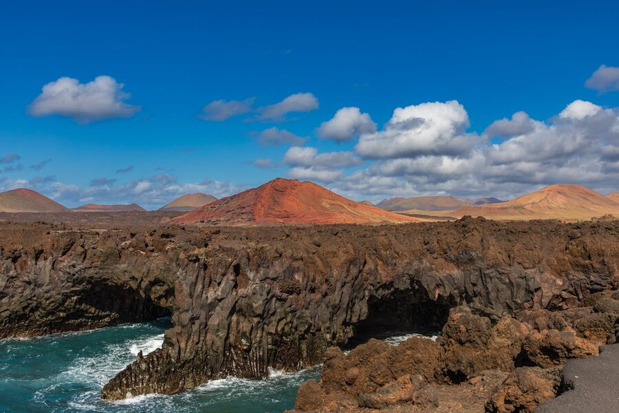 Volcanic coastline of Lanzarote with dark rocks and blue Atlantic Ocean