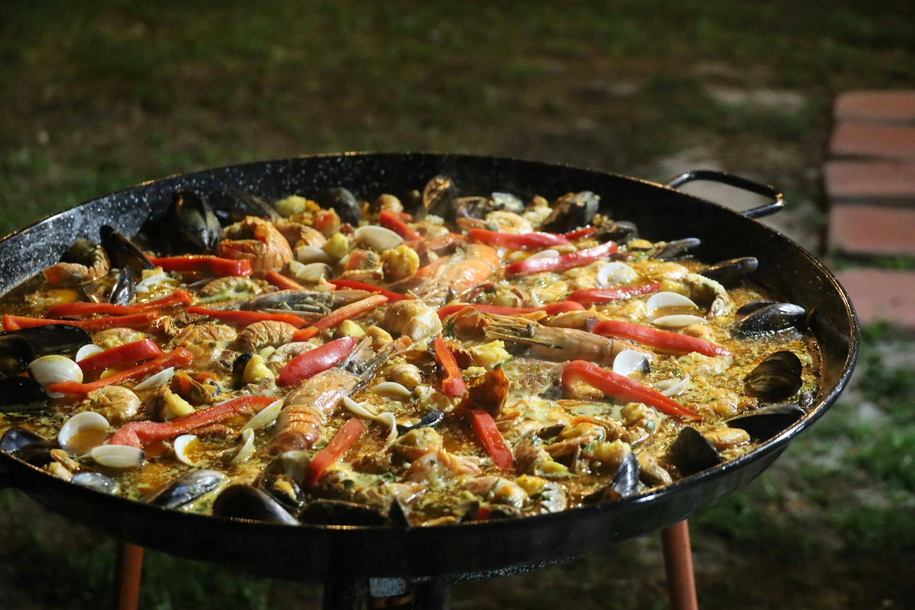 A large traditional paella being cooked outdoors