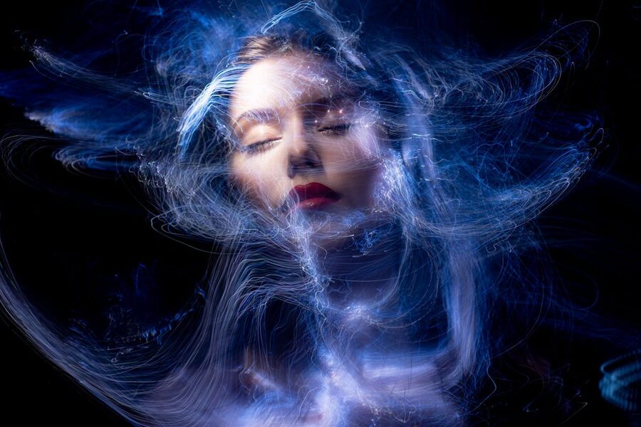 Abstract portrait of a woman with swirling blue neon light trails