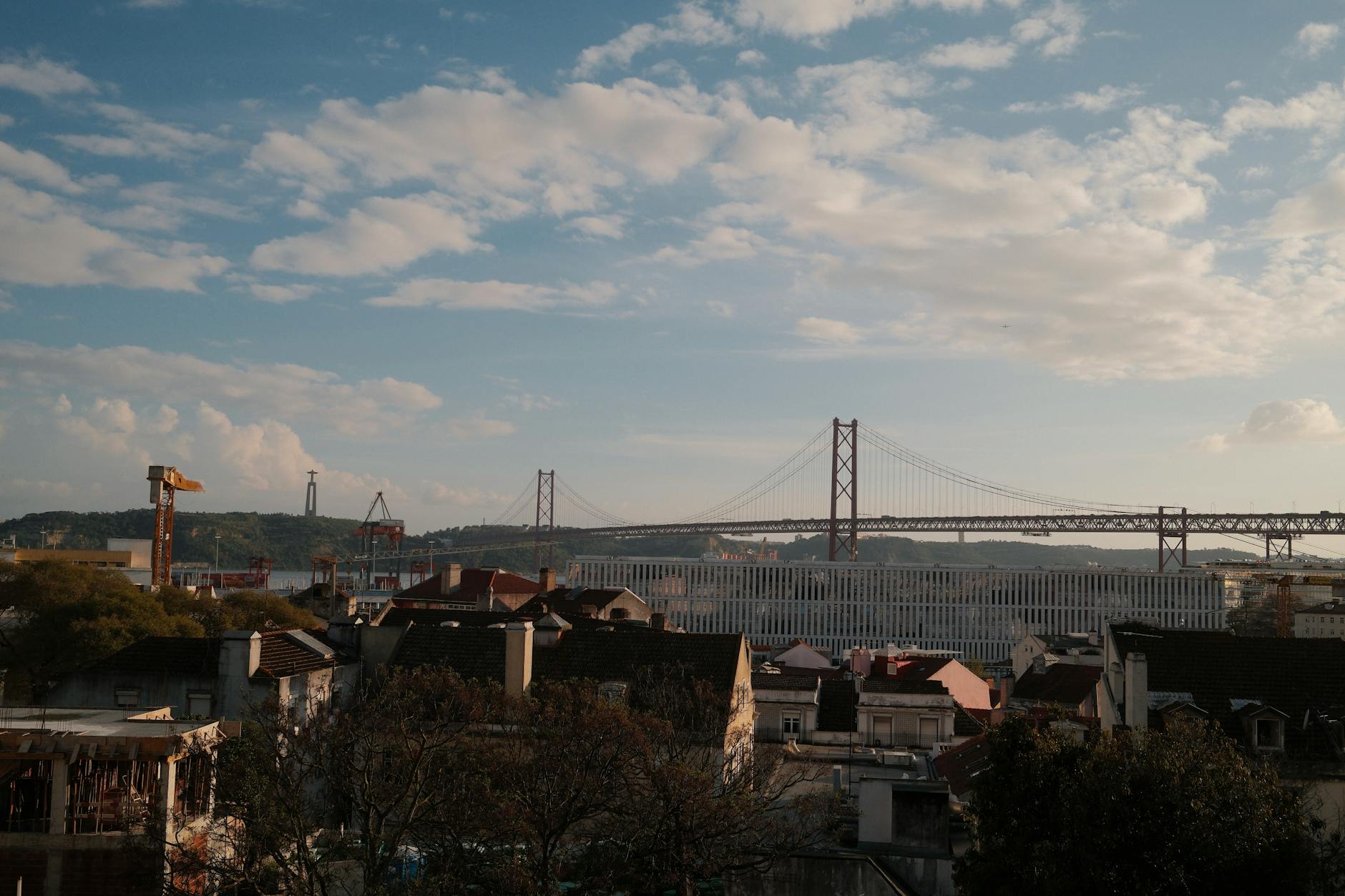 25 de Abril Bridge in Lisbon with rooftops and blue sky
