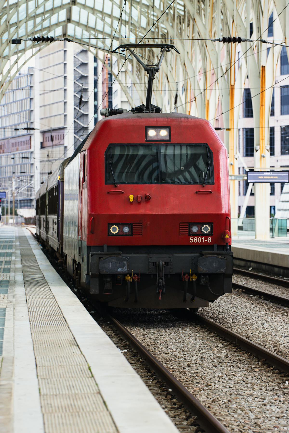 Red train arriving at Lisbon's Oriente Station platform
