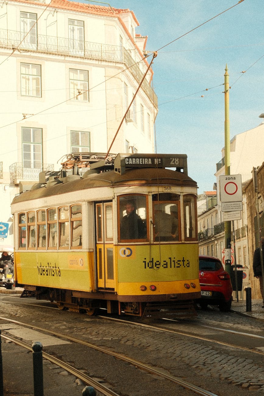 Classic Lisbon tram navigating through a narrow street