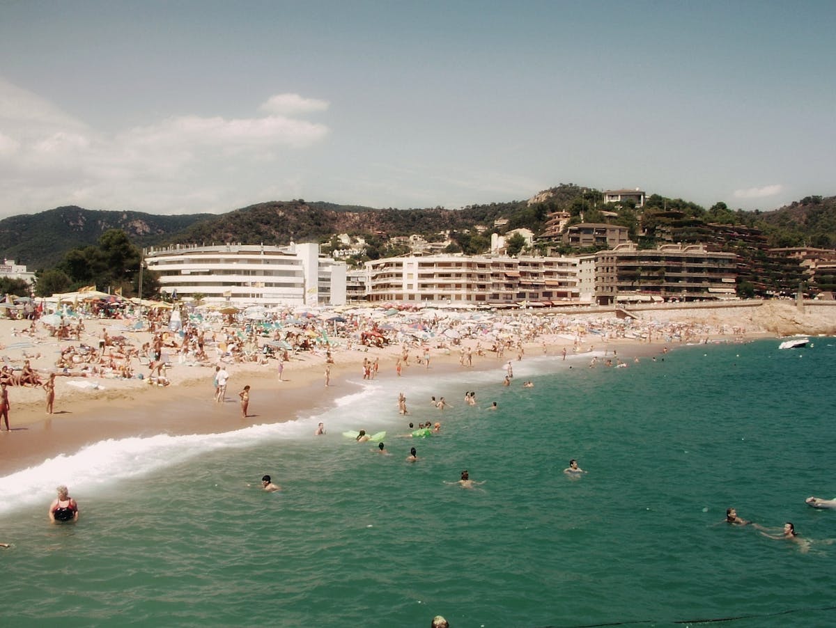 Lloret de Mar main beach filled with sunbathers and swimmers on a sunny day