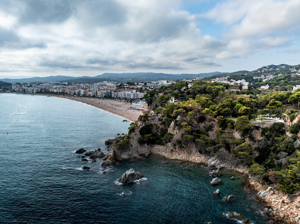 Coastline of Lloret de Mar with sandy beaches and lush vegetation