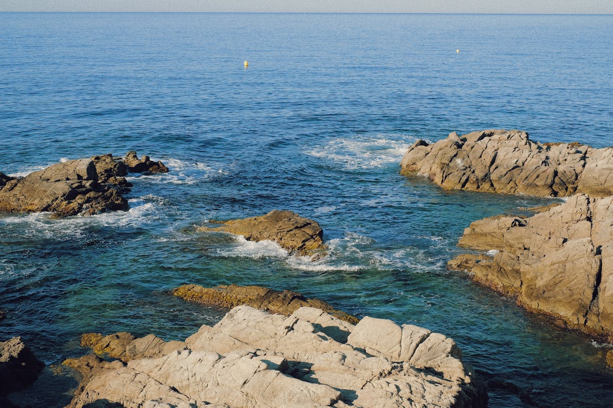Scenic rocky shoreline with clear blue waters in Lloret de Mar Spain