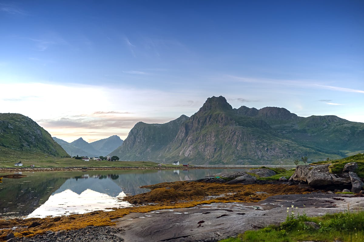 Lofoten Islands landscape with mountains reflected in calm waters at dawn