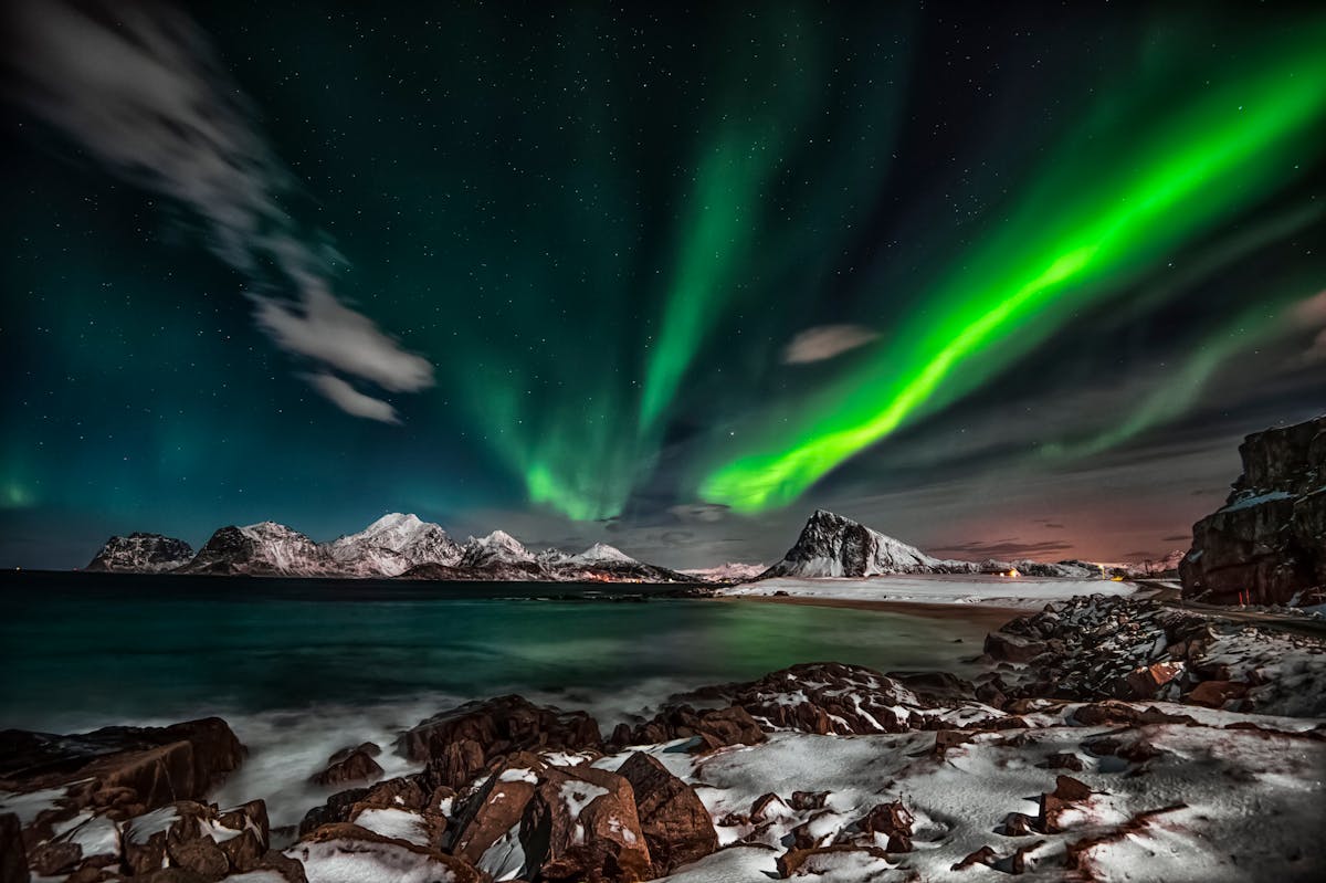 Northern Lights over snow-covered Lofoten Islands at night in Norway
