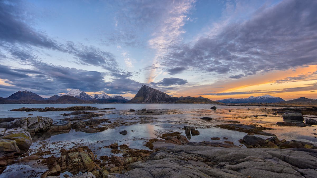 Sunset over rugged coastal landscape in Flakstad Lofoten Norway