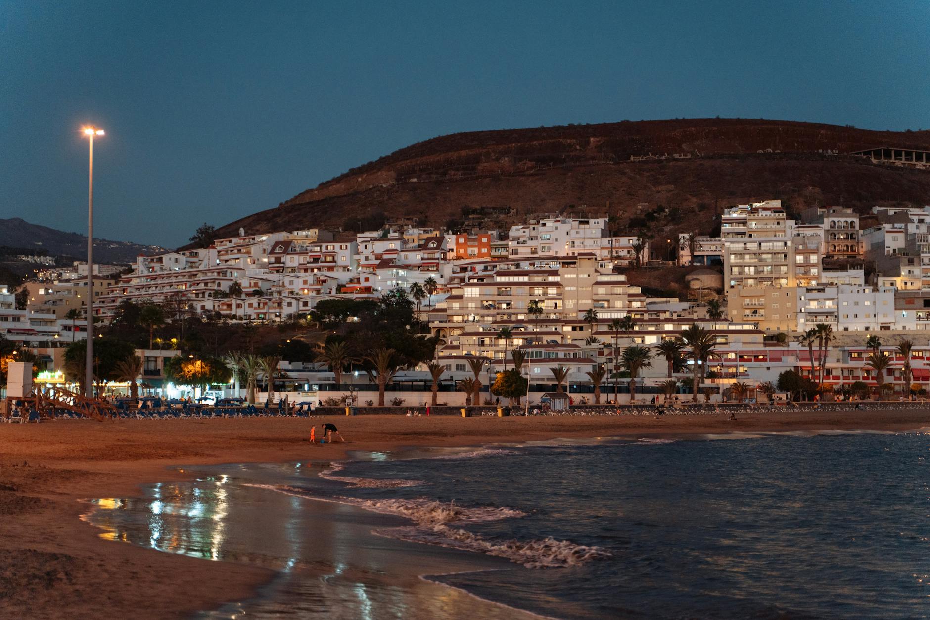Evening view of Los Cristianos with illuminated buildings along the beach