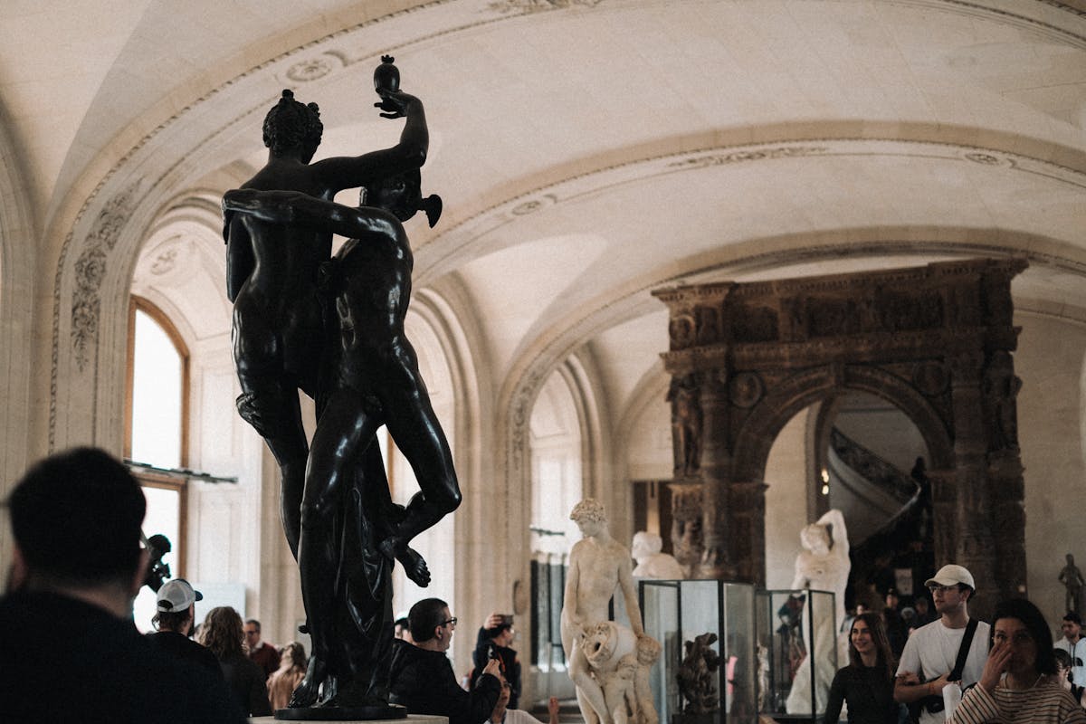 Tourists admiring Mercury Abducting Psyche sculpture in the Louvre Museum