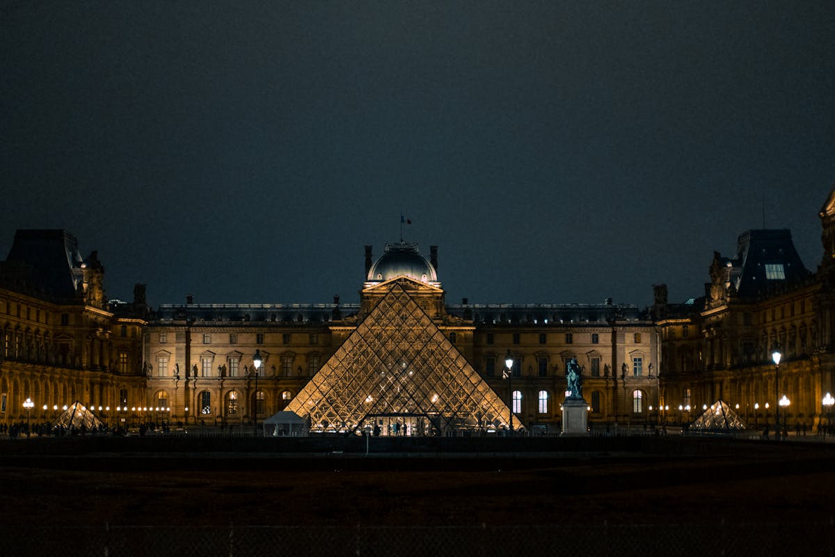 The Louvre Pyramid glowing against the Paris night sky