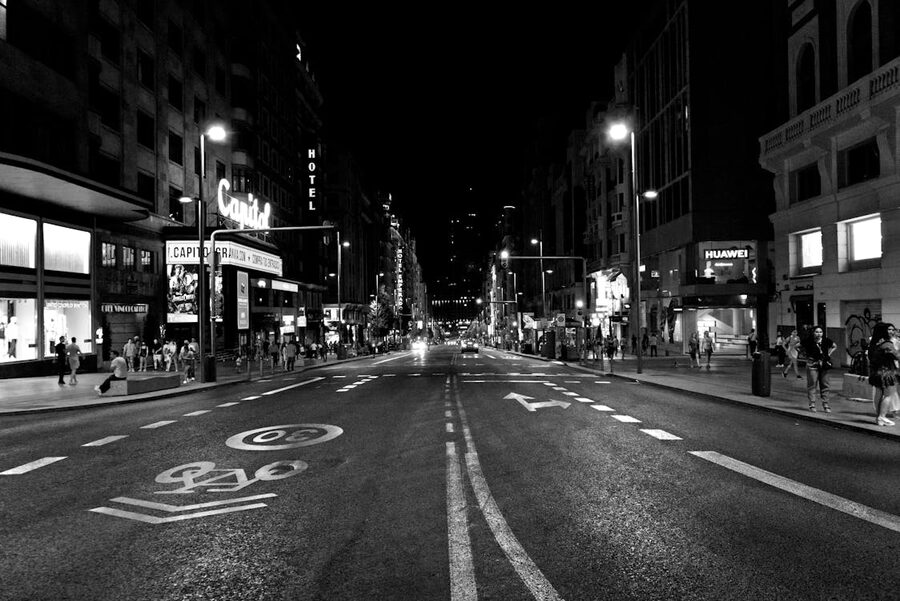 Gran Via in Madrid at night with neon signs and people walking