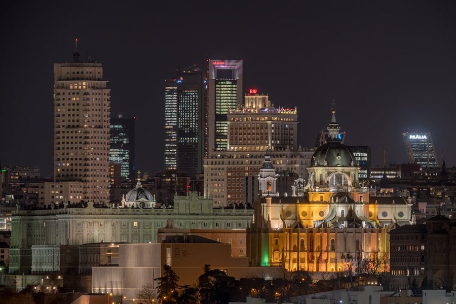 Madrid cityscape illuminated at night with landmark buildings along the skyline