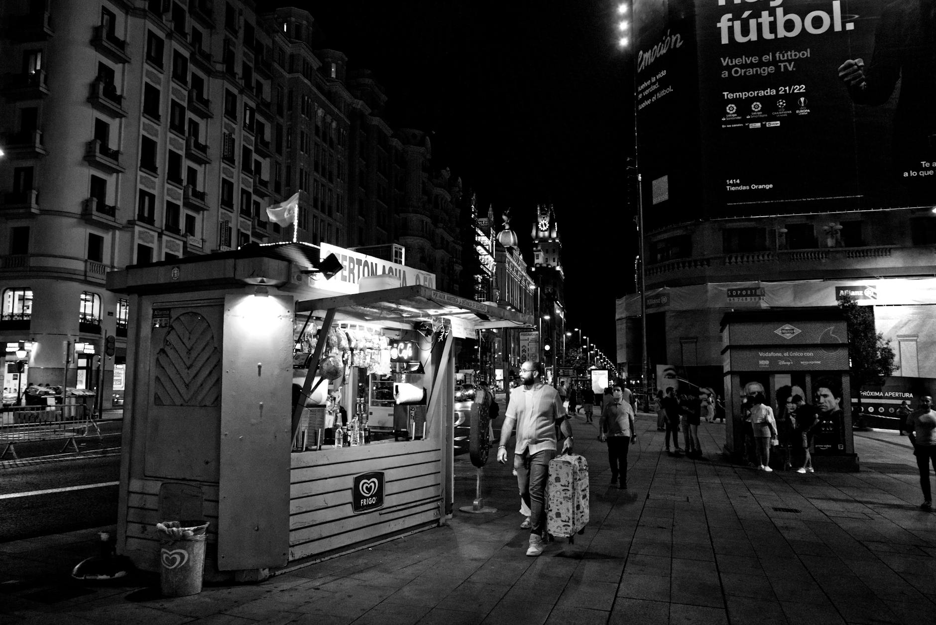 Night street scene in Madrid with food stalls and people